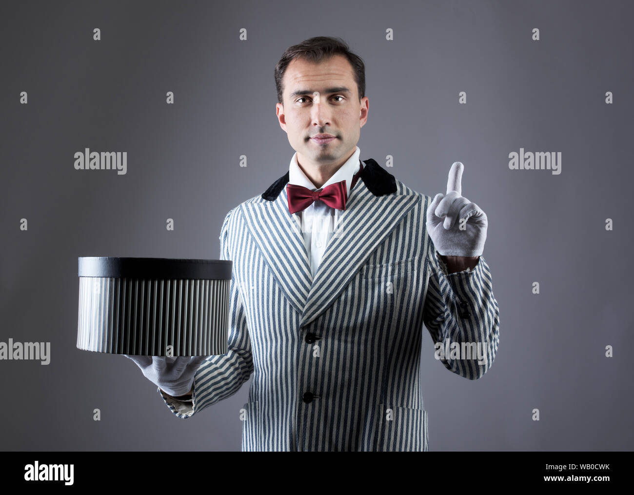 Magician showing tricks with a striped box Stock Photo - Alamy