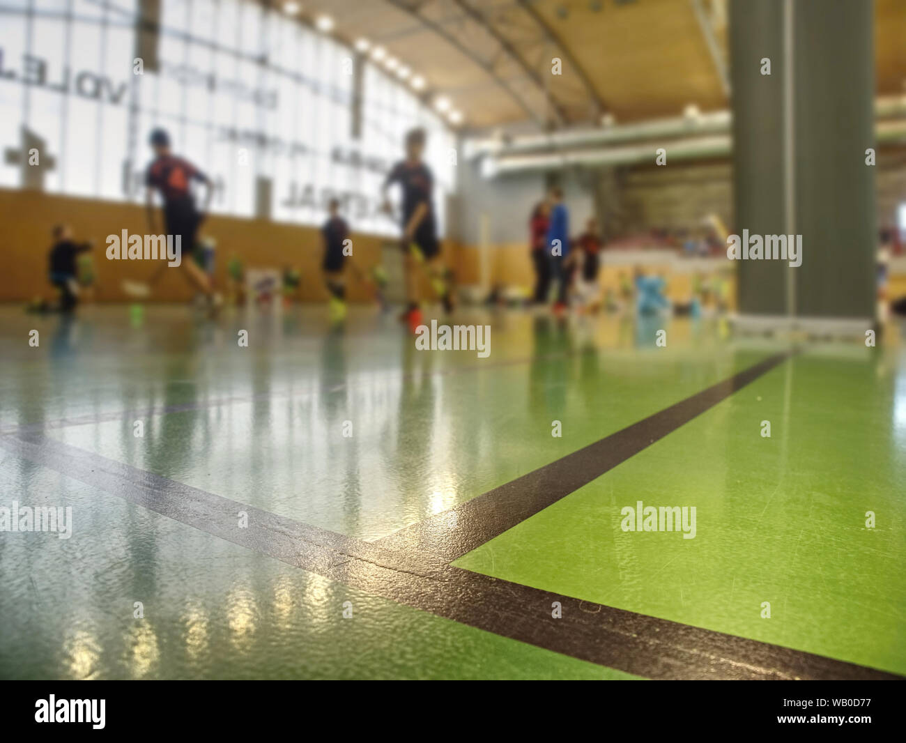 Detail of floor surface marked with black lines. Players out of focus ...