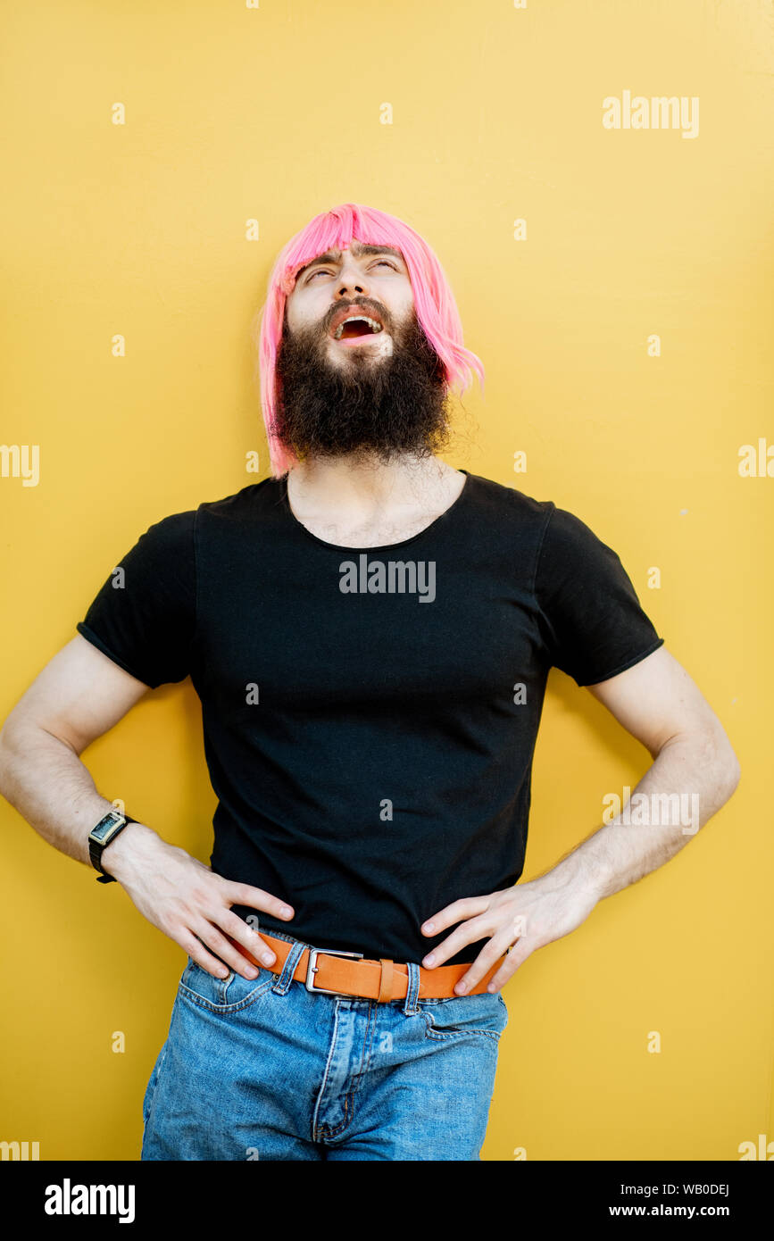 Funny portrait of a stylish playful man with beard and long color hair ...