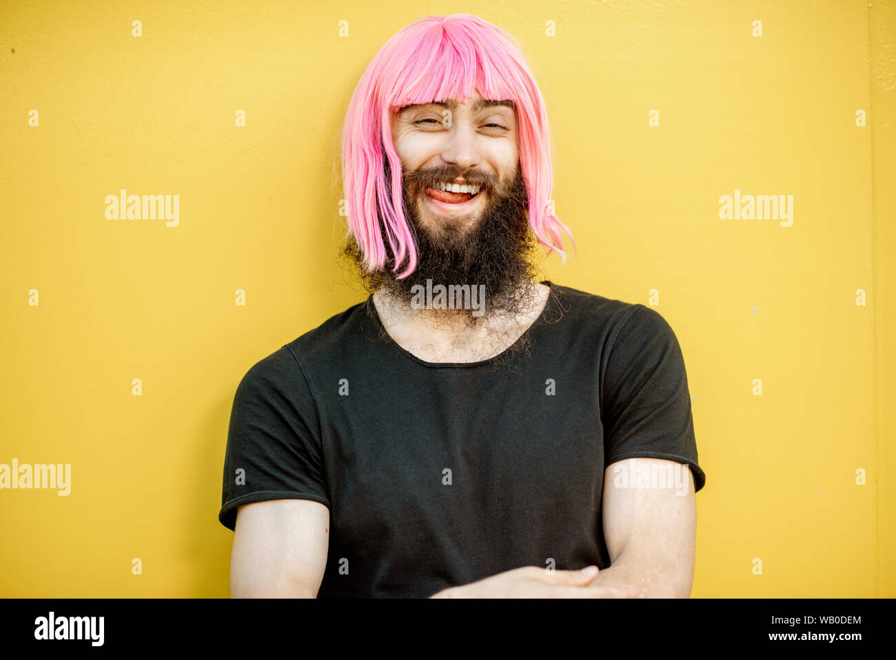 Funny portrait of a stylish playful man with beard and long color hair ...