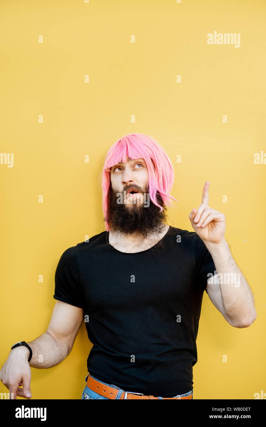 Funny portrait of a stylish playful man with beard and long color hair ...