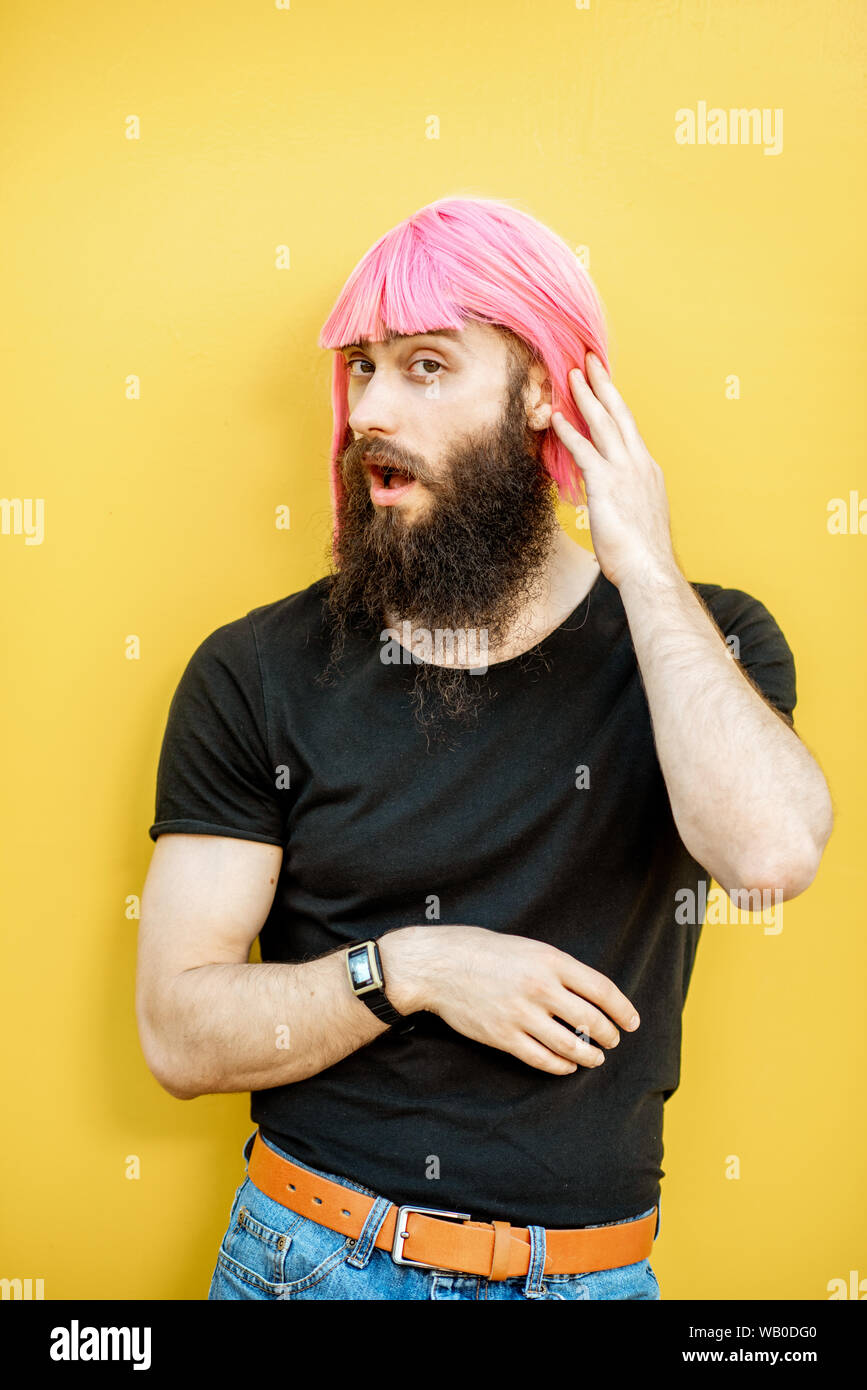 Funny portrait of a stylish playful man with beard and long color hair ...