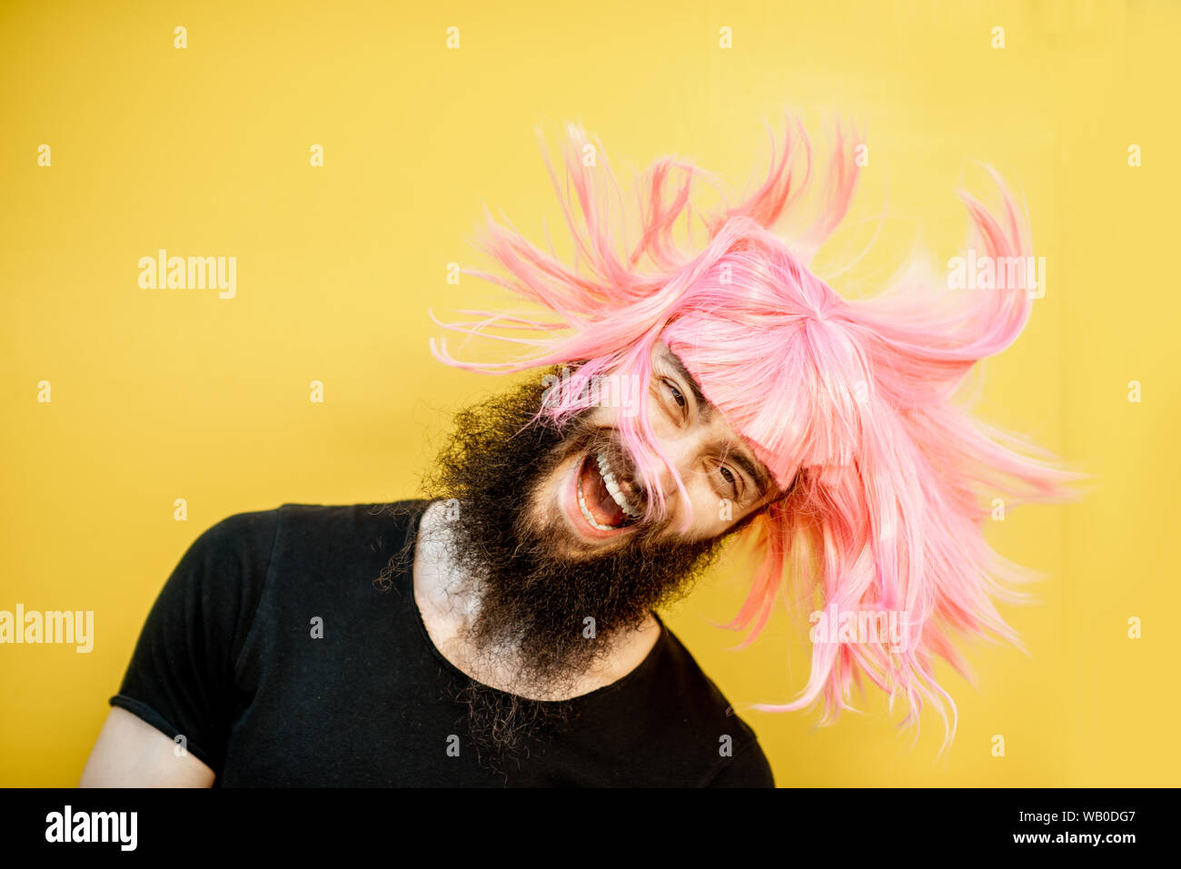 Funny portrait of a stylish playful man with beard and long color hair ...