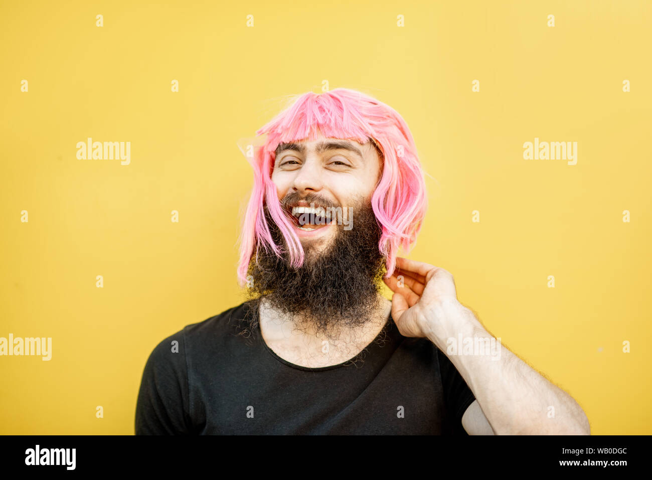 Funny portrait of a stylish playful man with beard and long color hair ...