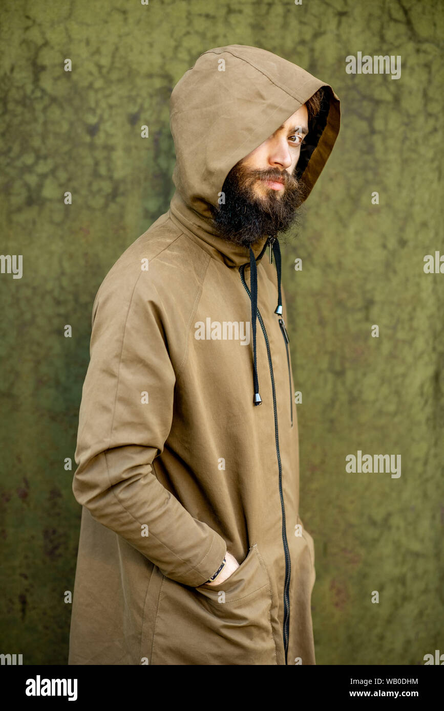 Portrait of a mysterious and weird man wearing hoodie coat on the green ...