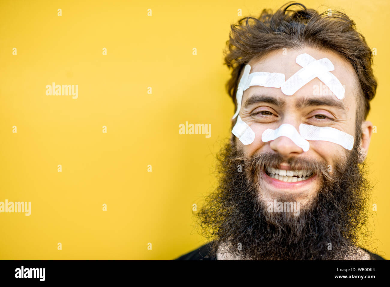 Close-up portrait of an injured man with medical patches on his face on ...