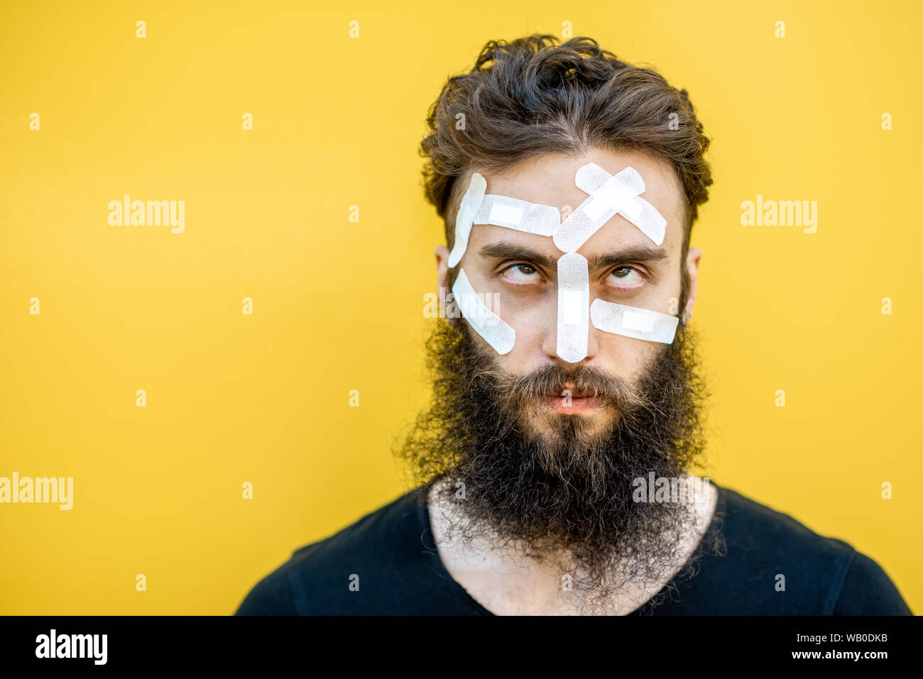 Close-up portrait of an injured man with medical patches on his face on ...