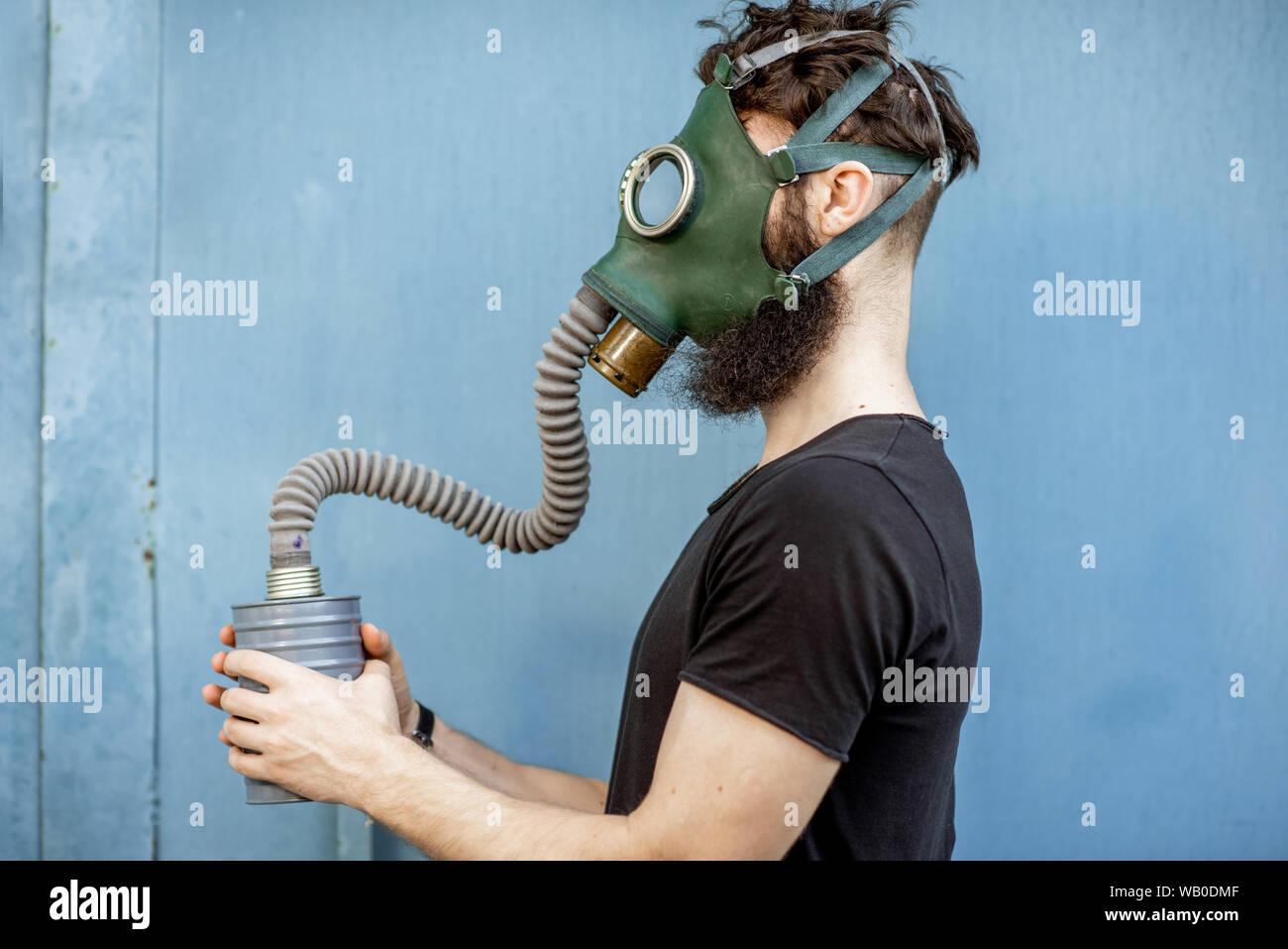 Portrait of a man with gas mask on the blue background. Concept of poor ...