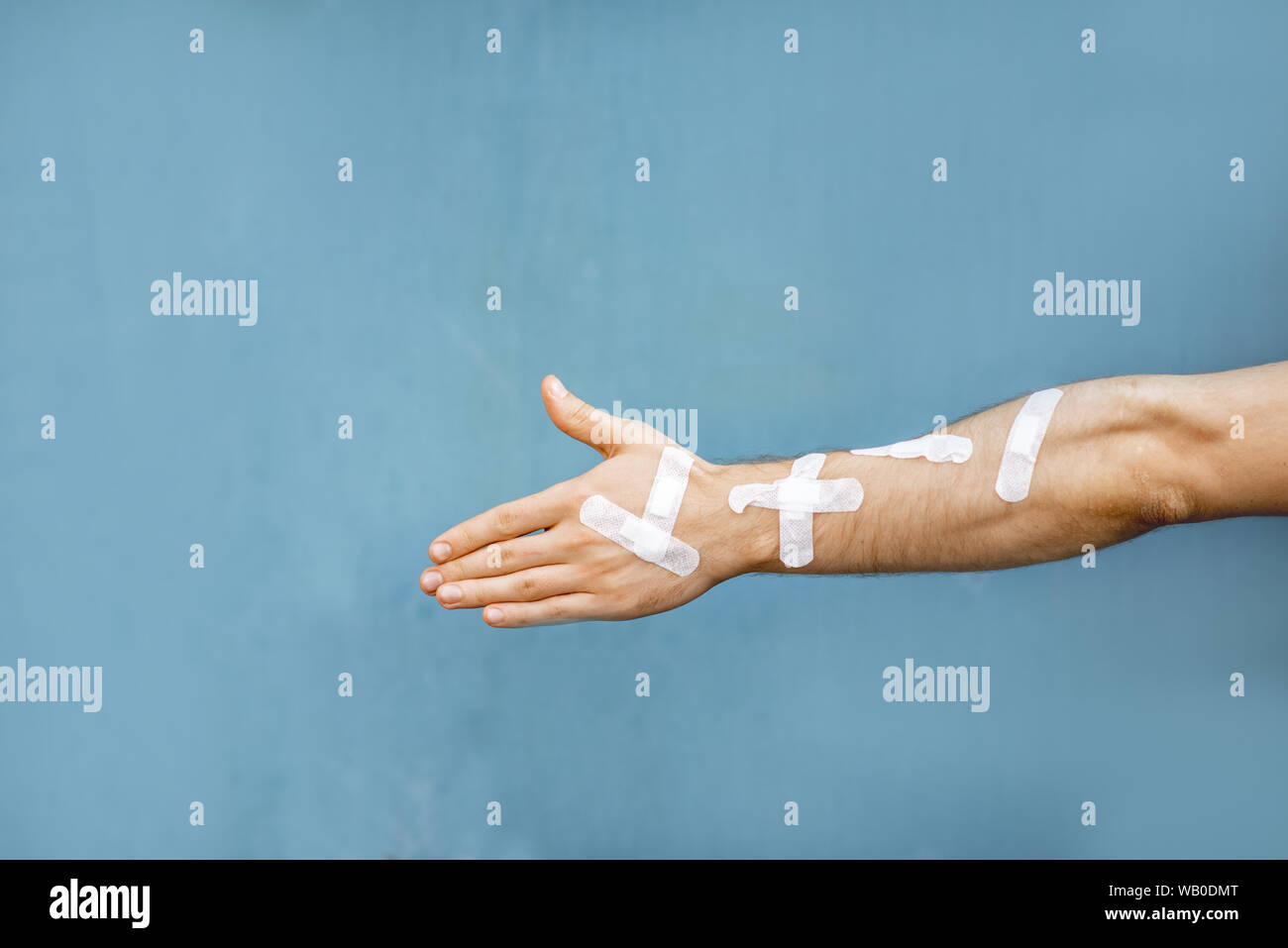 Male hand with medical patches on the blue background Stock Photo - Alamy