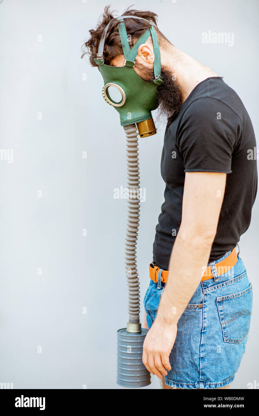 Portrait of a sad man with gas mask on the grey background. Concept of ...