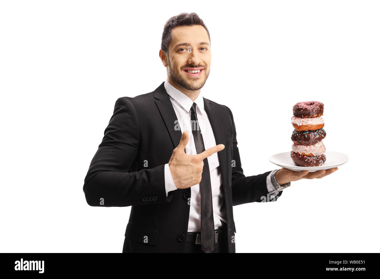 Businessman holding a plate of chocolate donuts and pointing isolated ...
