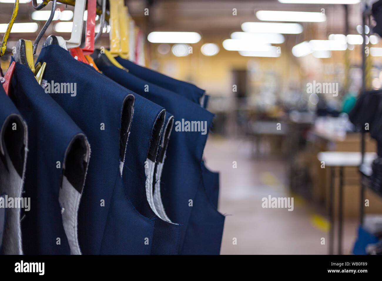 Unfinished suit jackets hanging on assembly line in European garment ...