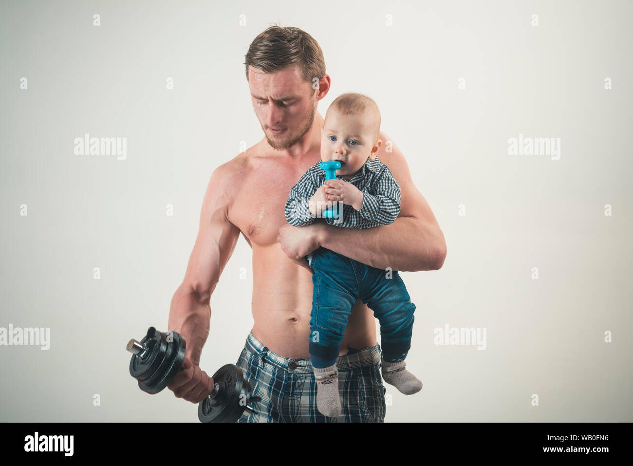 Fit and muscular. Father and son build biceps triceps. Father and child ...