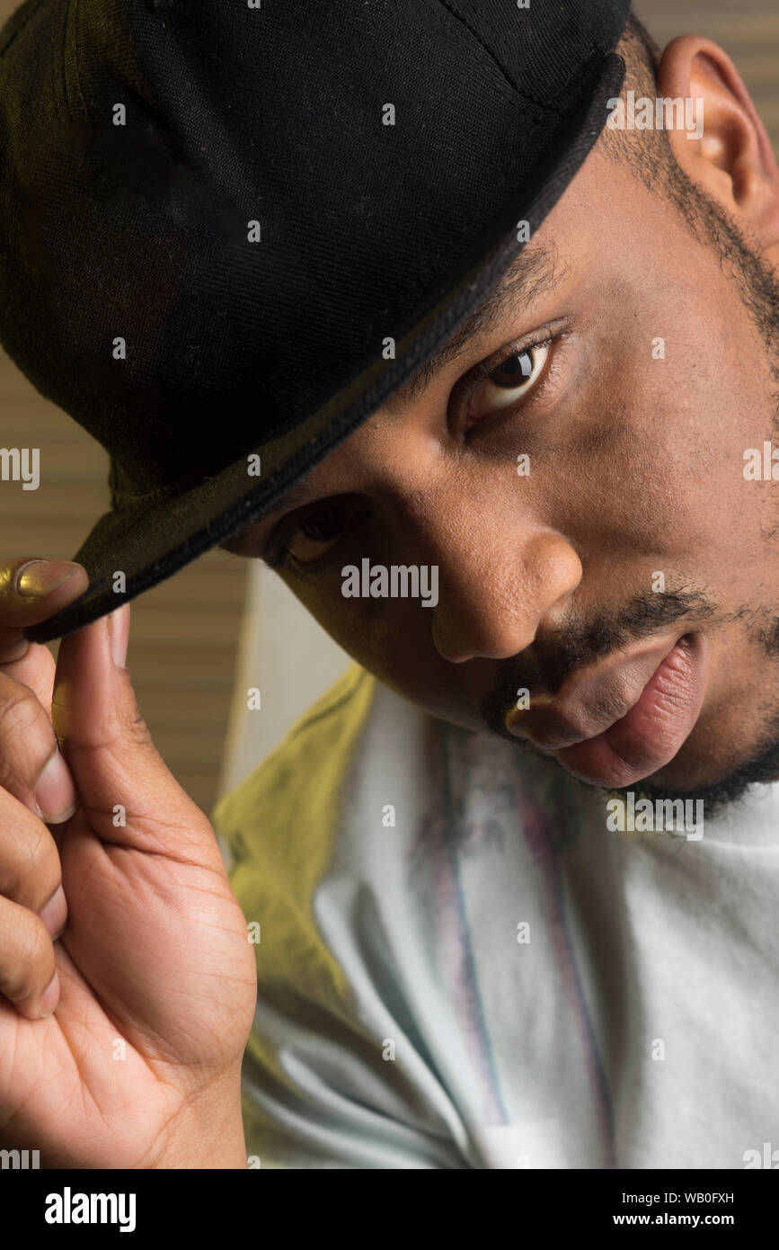 Rapper culture concept. Black macho with beard wears rapper cap and ...