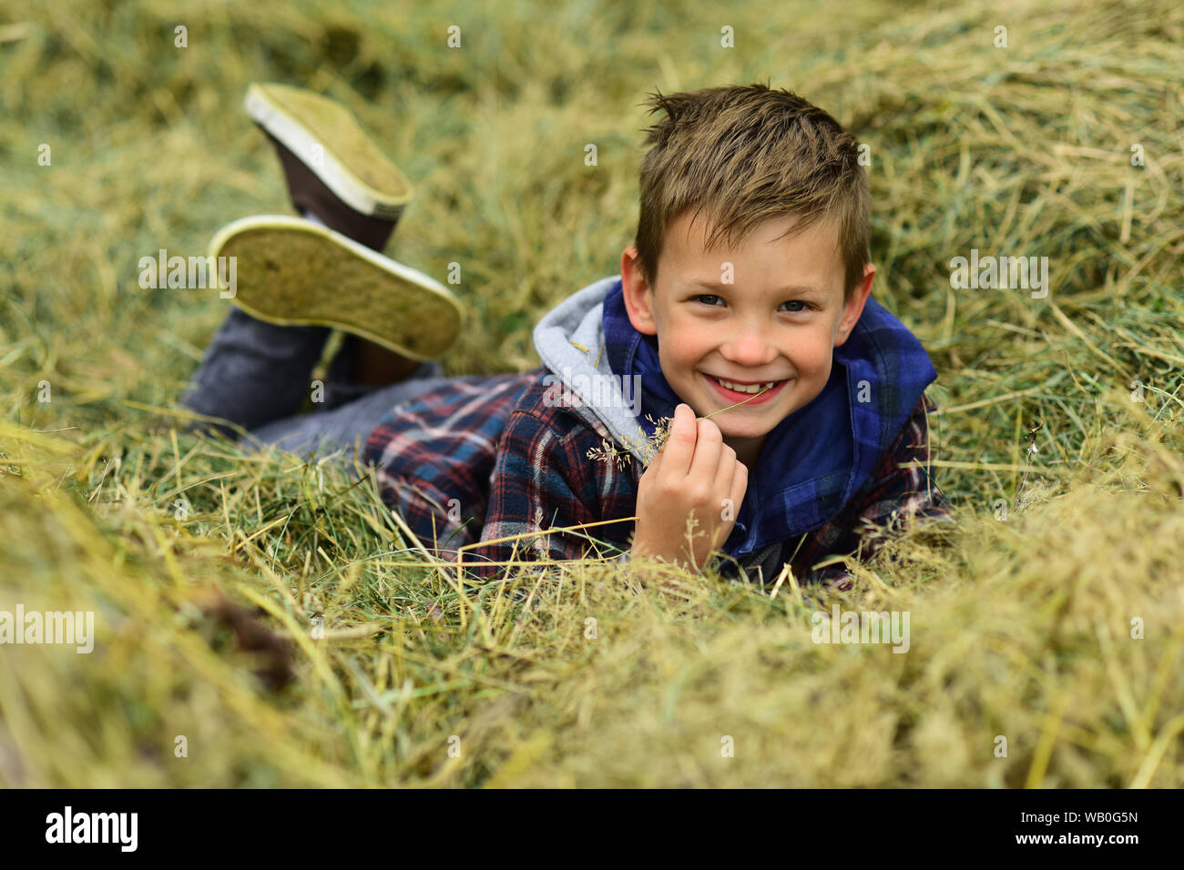 The body needs its rest. Healthy boy. Small boy relax in hay. Small boy ...