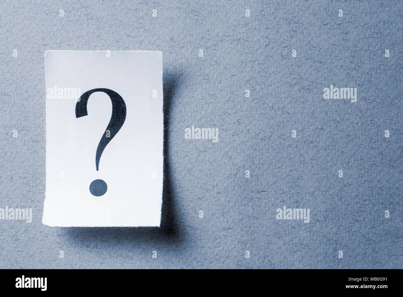 Single curled card with printed question mark placed to the side on a ...