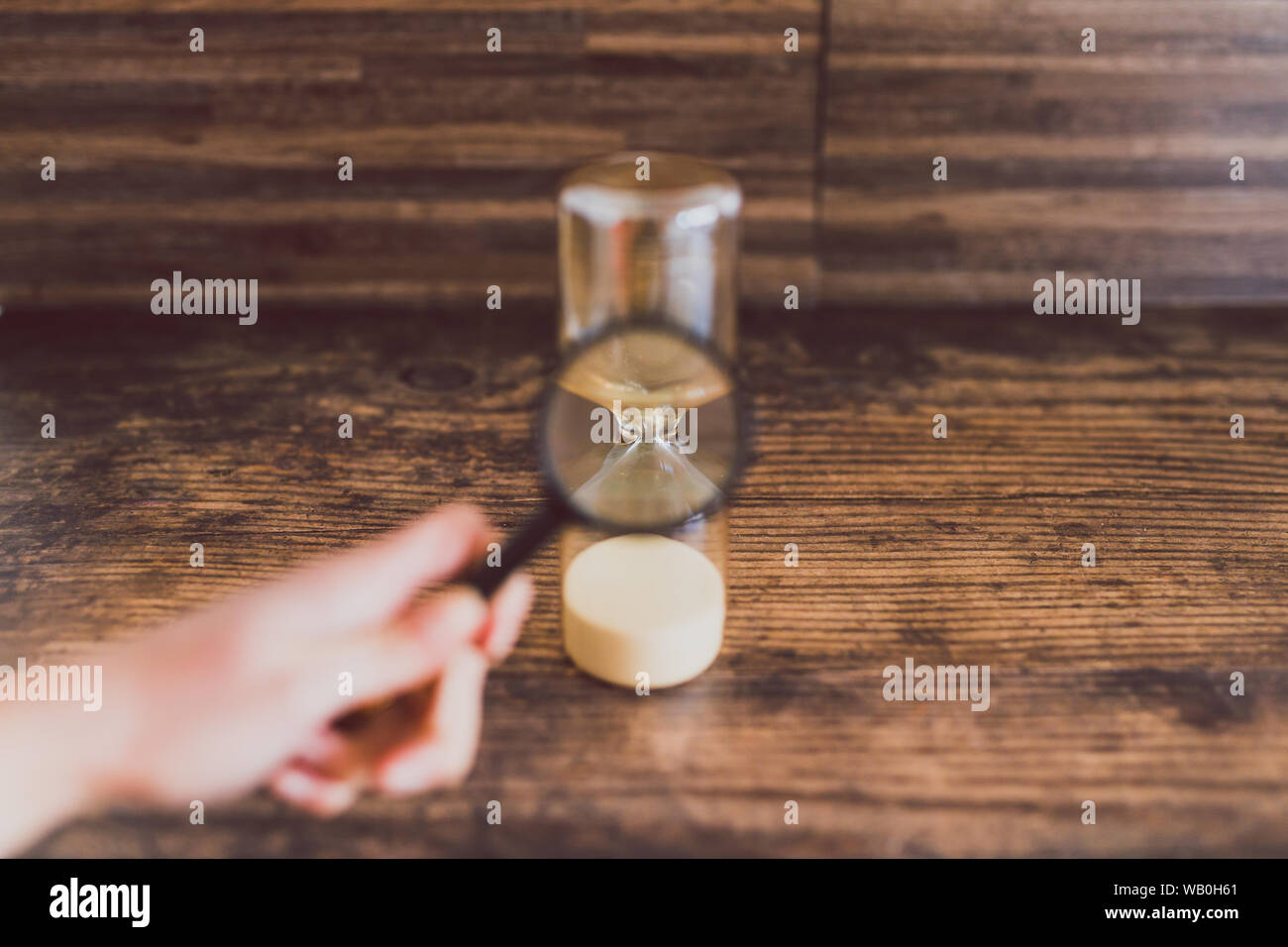 hand holding magnifying glass analyzing time passying by with an ...