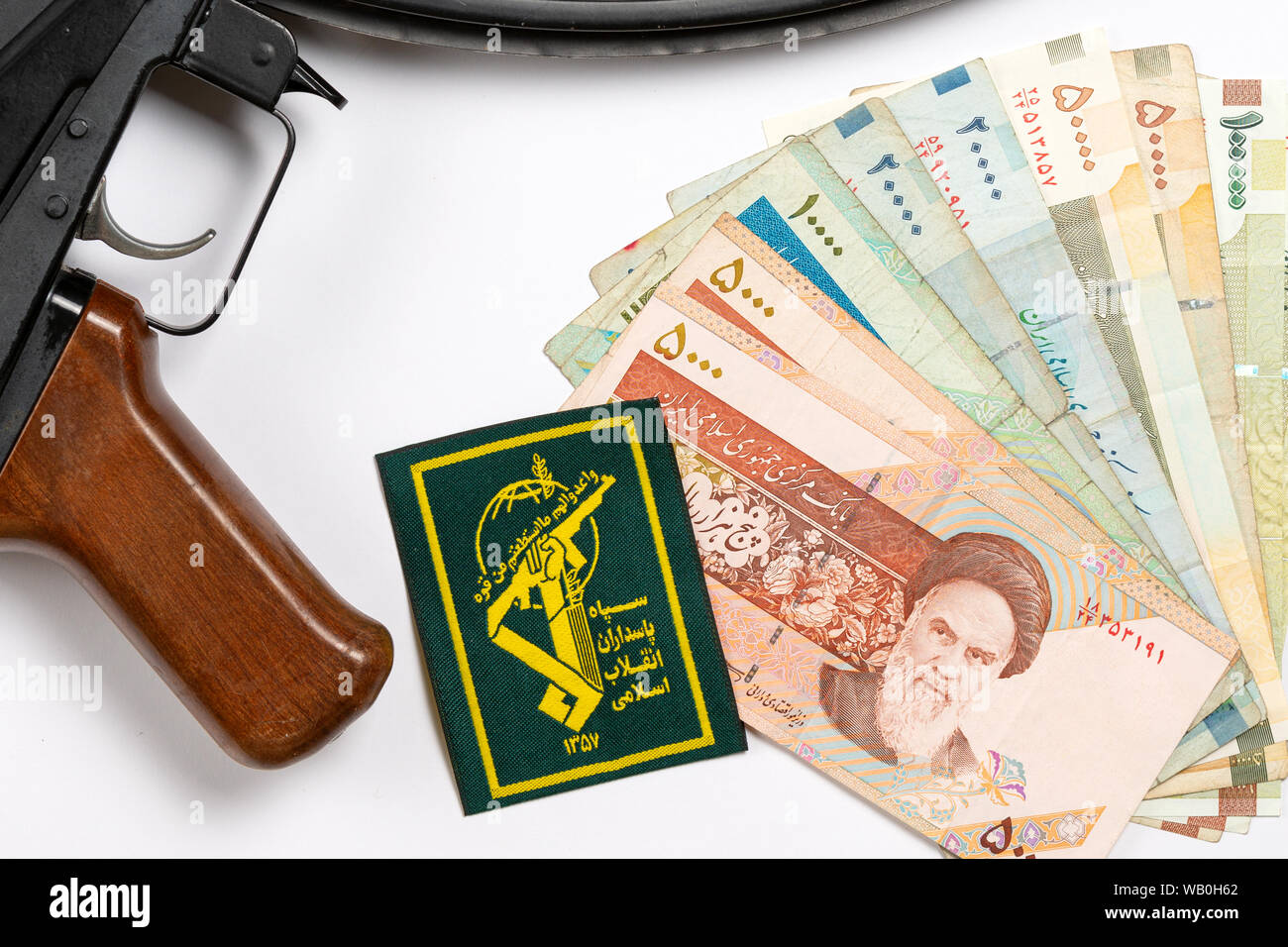 Soviet automaton AK 47 against the backdrop of Iranian money depicting ...