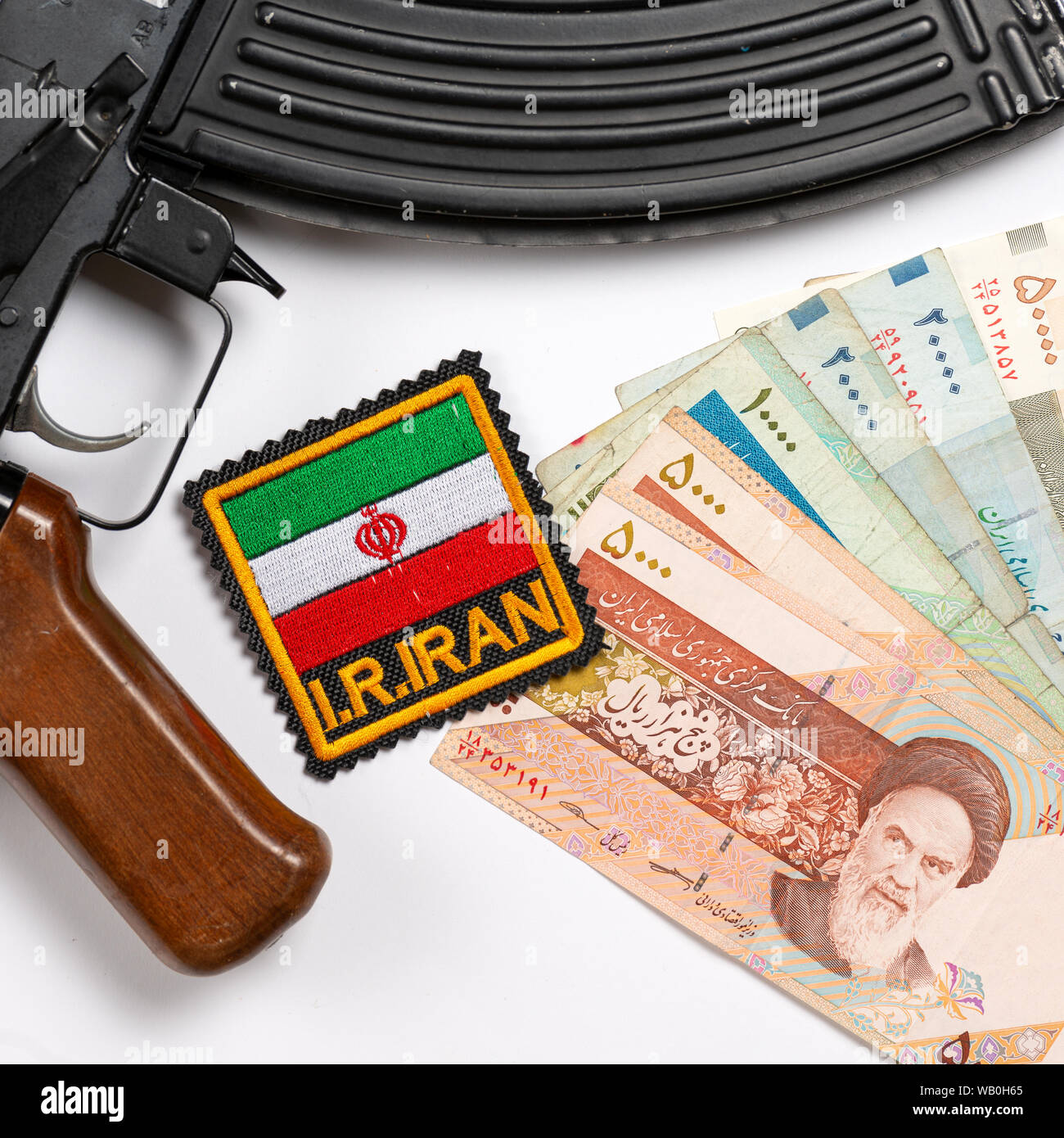 Soviet automaton AK 47 against the backdrop of Iranian money depicting ...