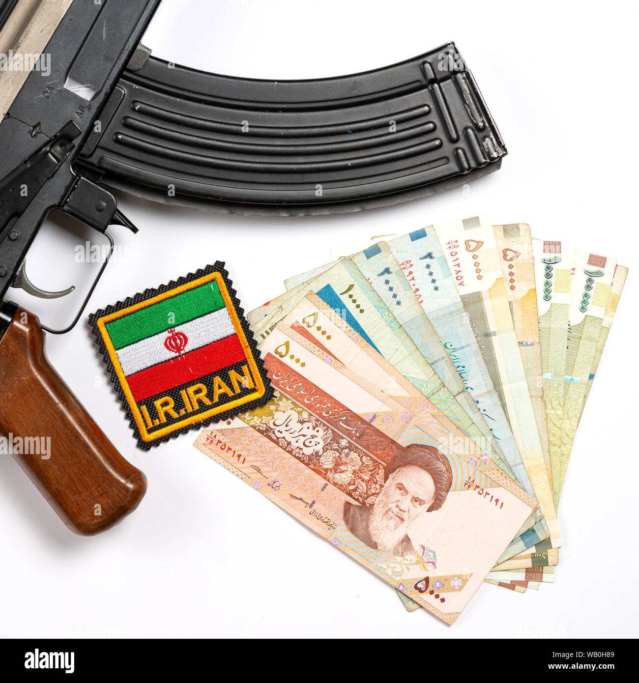 Soviet automaton AK 47 against the backdrop of Iranian money depicting ...