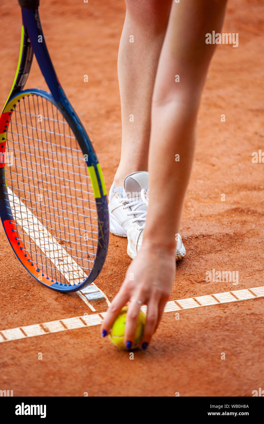 Female Tennis Player Legs In Tennis Shoes Standing On A Clay Court