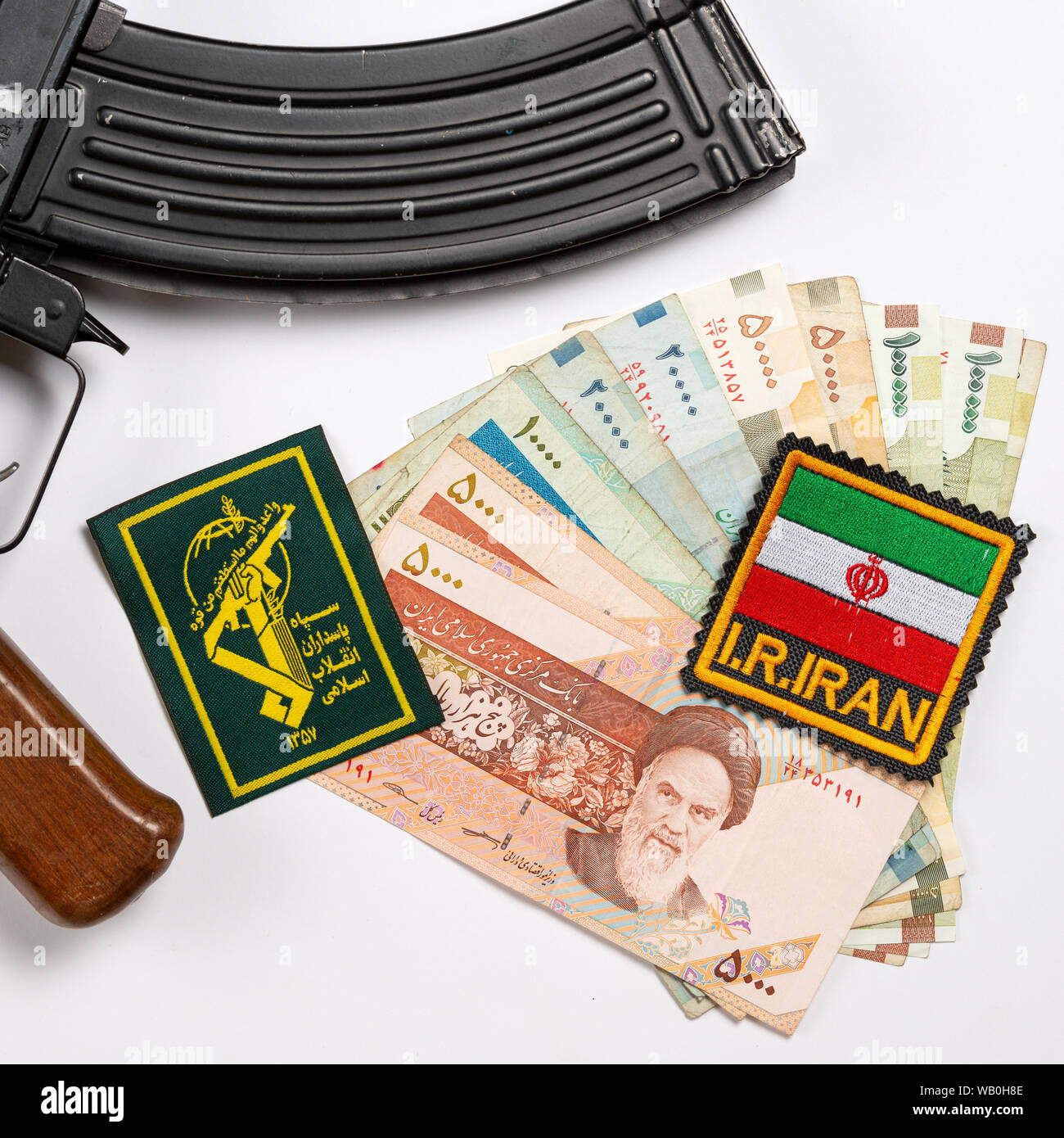 Soviet automaton AK 47 against the backdrop of Iranian money depicting ...