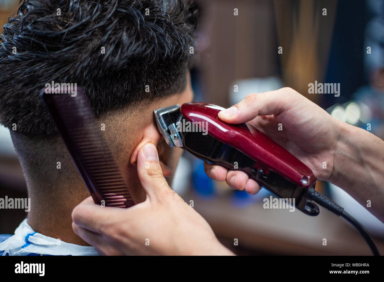 Close up shot of man getting trendy haircut at barber shop. Male ...