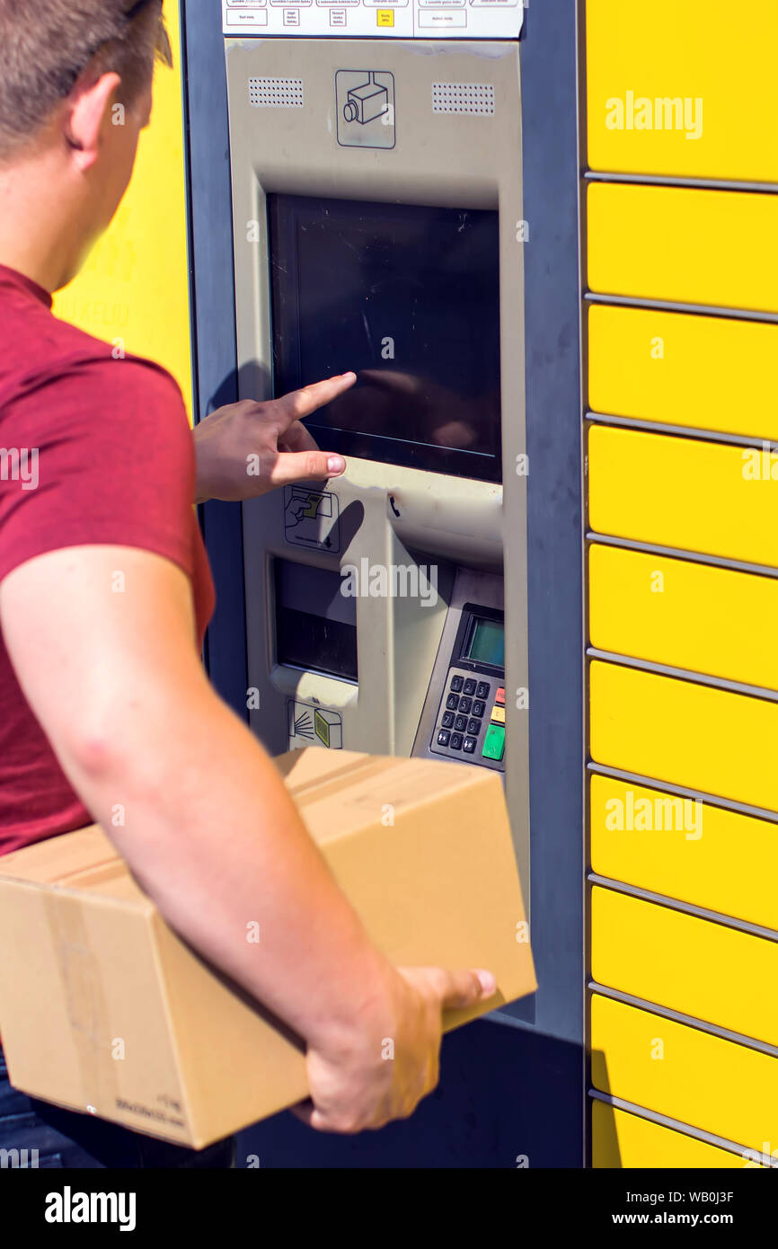 Man using automated self-service post terminal machine or locker to ...