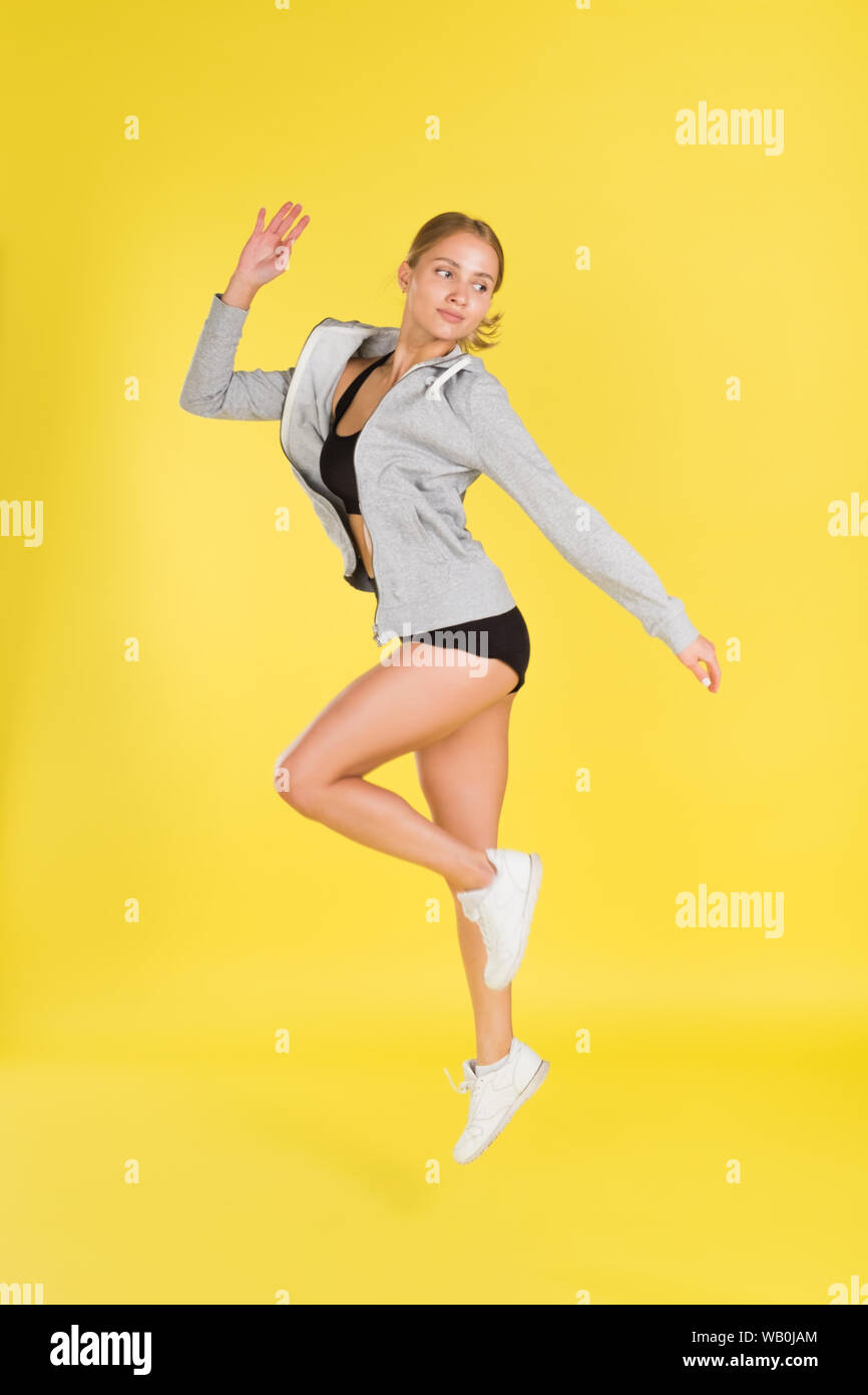 Young woman jumping in silhouette on yellow background. Dynamic ...