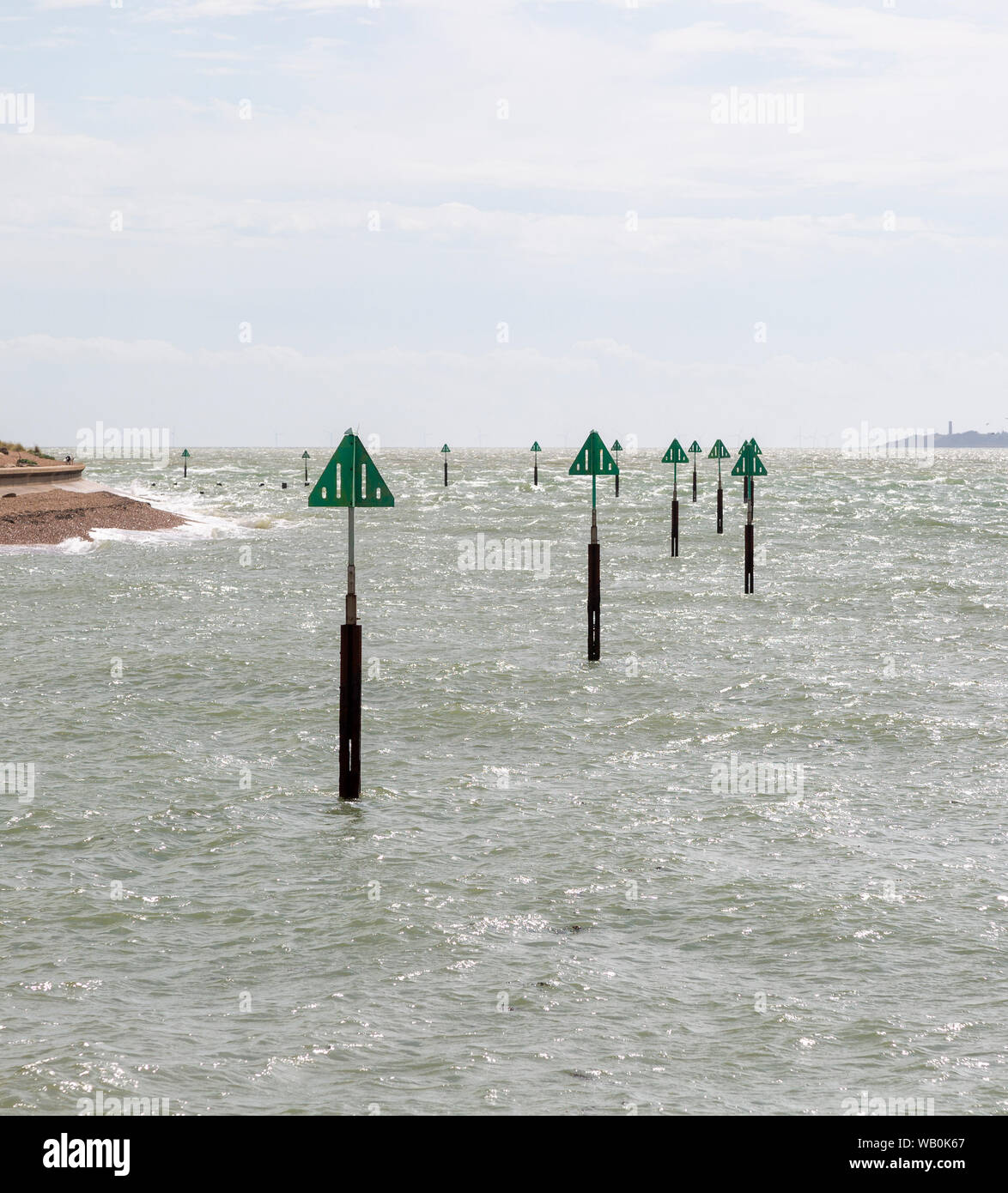 Green triangular warning markers on posts in shallow water at River ...