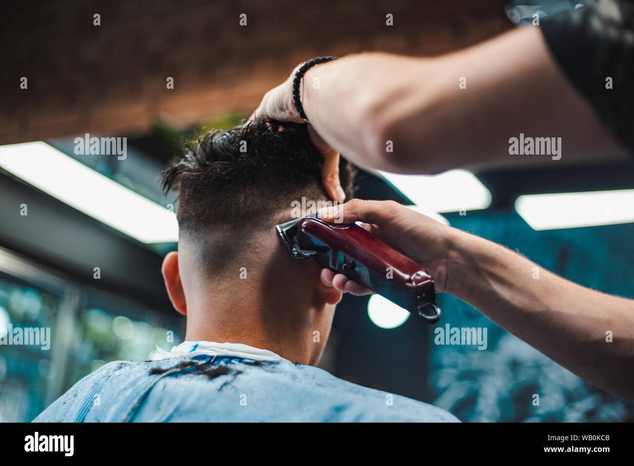 Close up shot of man getting trendy haircut at barber shop. Male ...