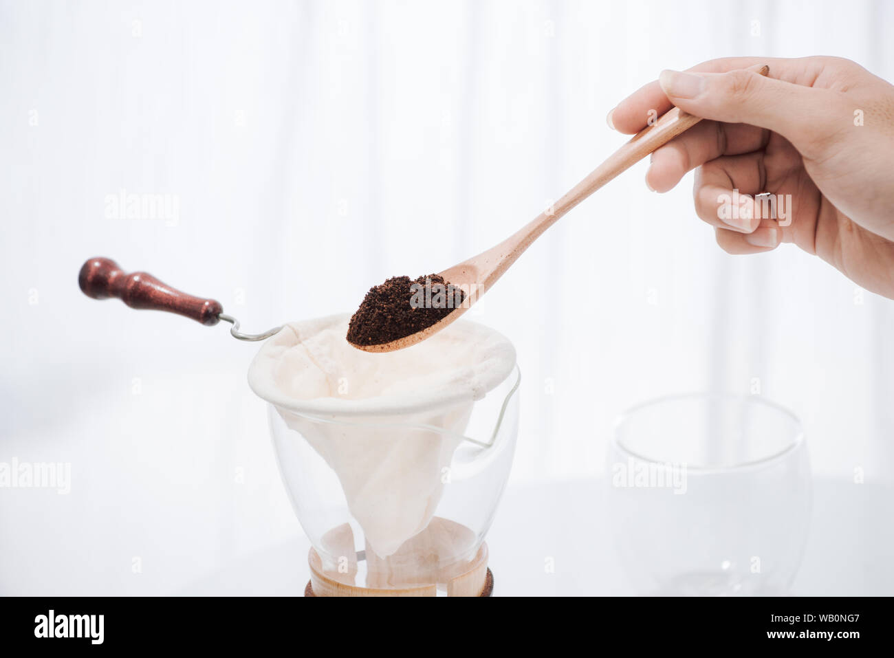 fill grind coffee in filter with wooden spoon Stock Photo - Alamy