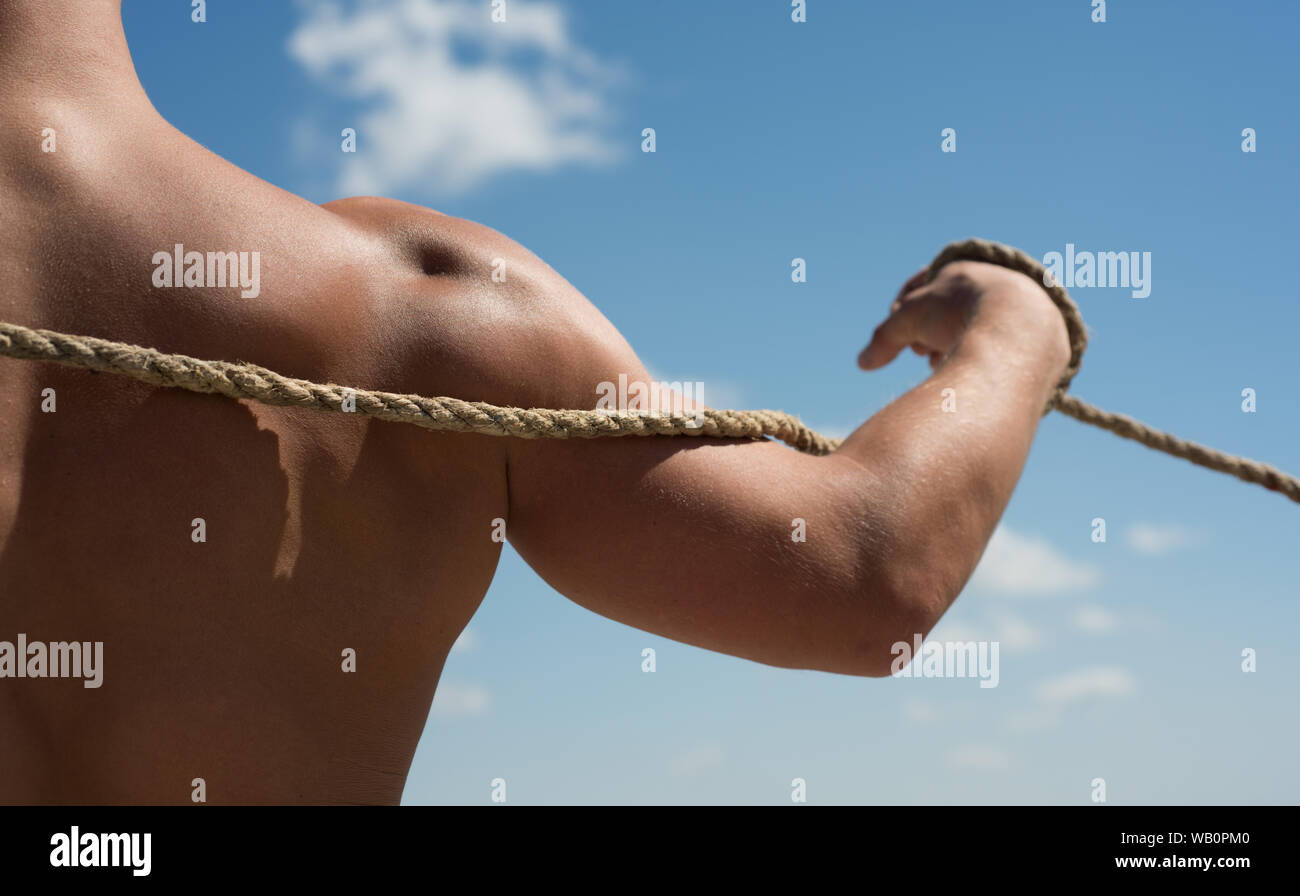 Increasing muscles power. Strong arm and shoulders tugging rope. Test ...