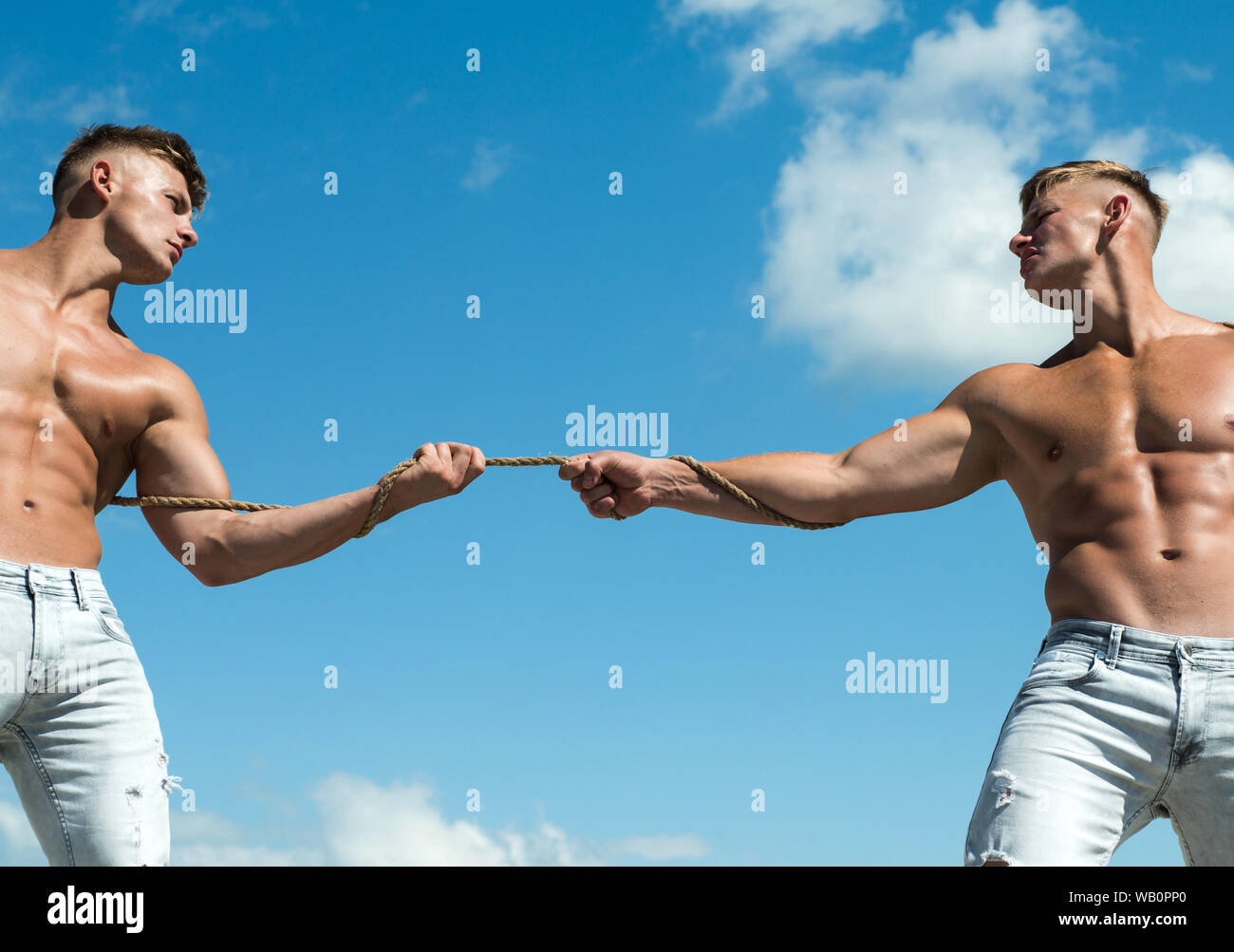 Feeling power. Strong men pull rope with muscular hand strength. Men ...