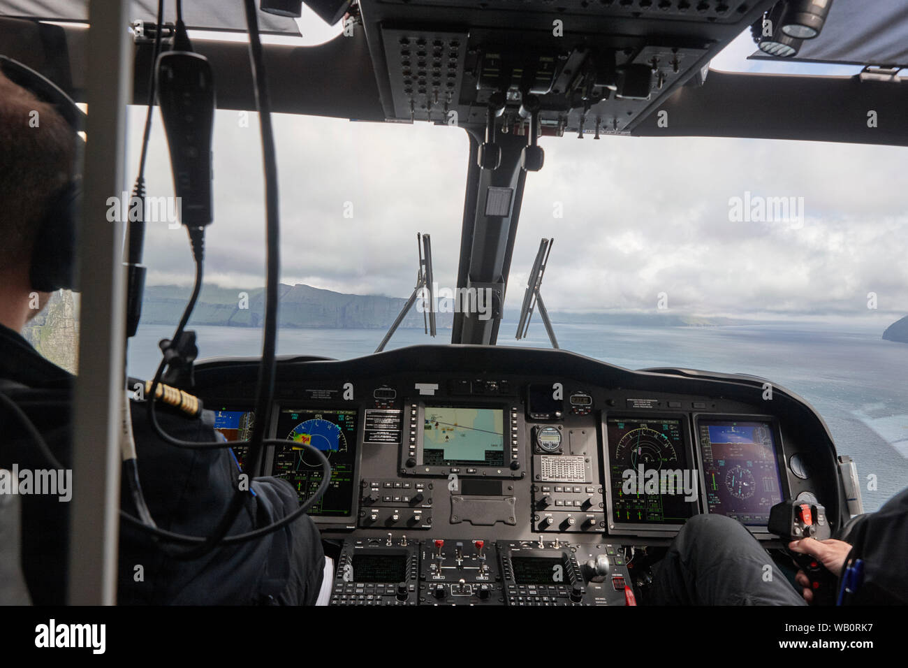 Helicopter cabin with pilots flying over Faroe Islands. Denmark Stock ...