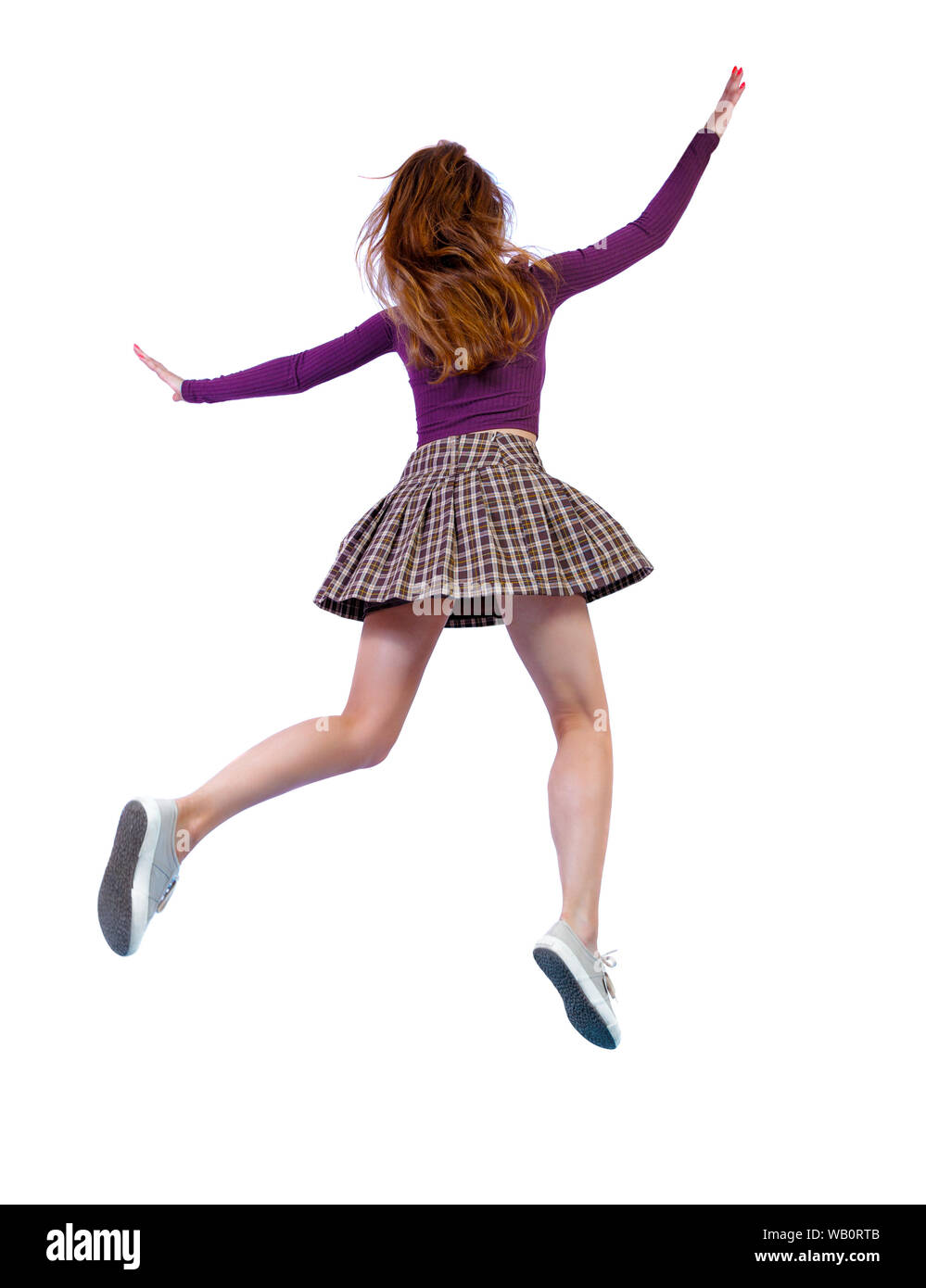 Back view of girl in a jump. Red-haired girl jumps. back side view of ...
