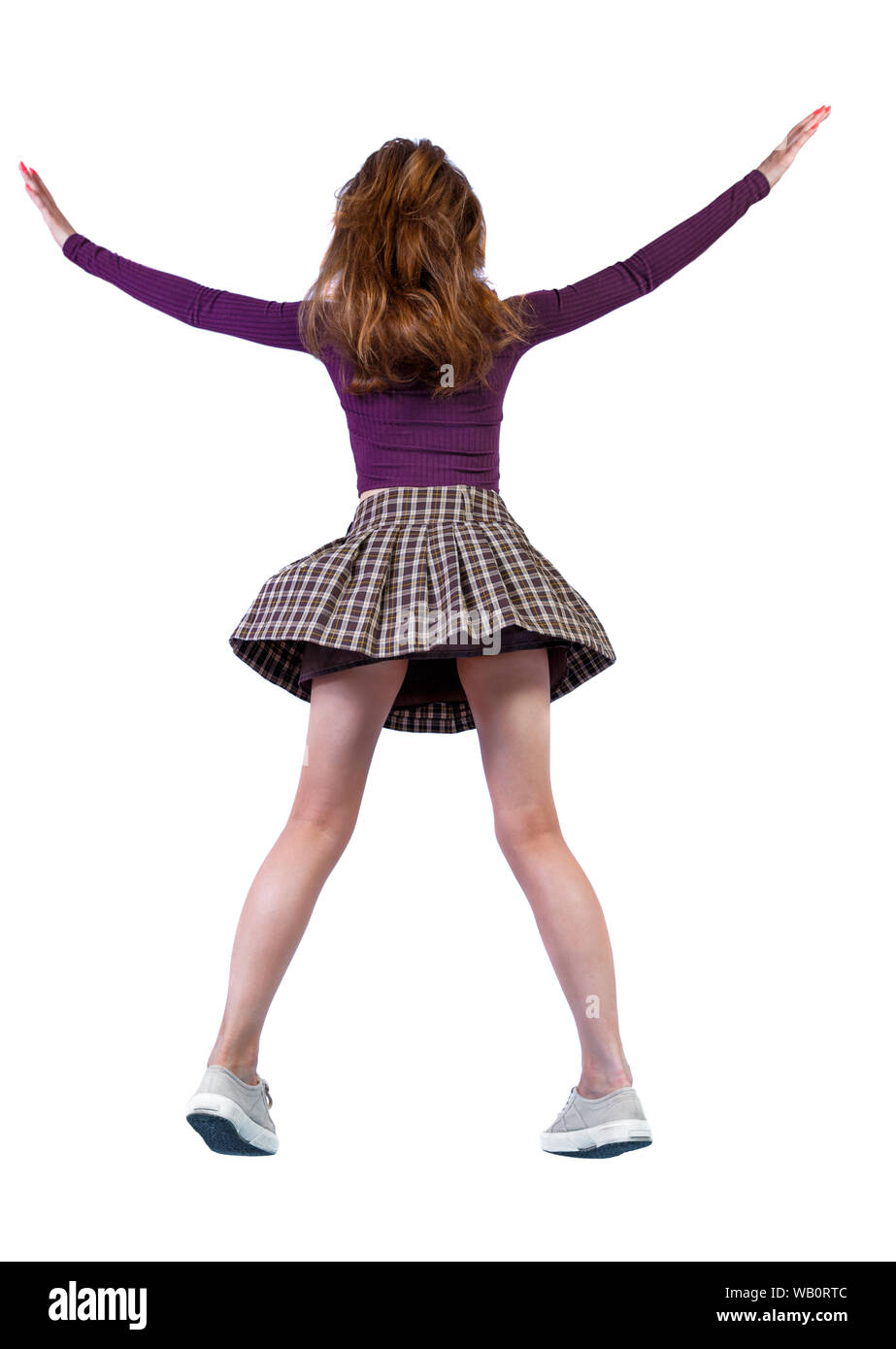 Back view of girl in a jump. Red-haired girl jumps. back side view of ...