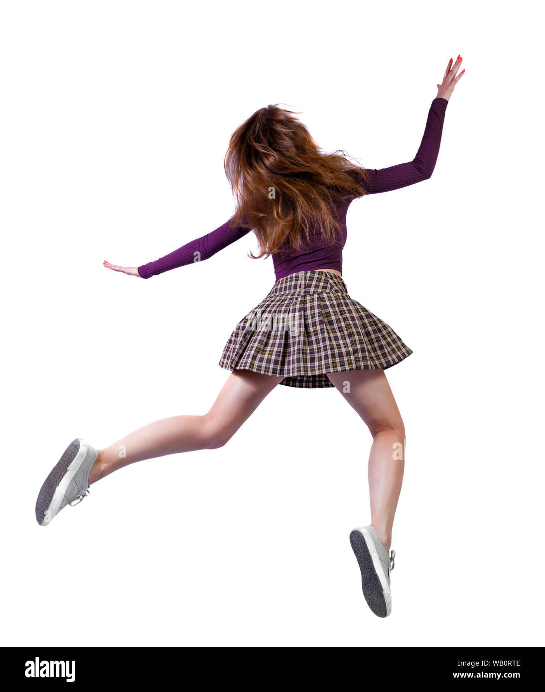 Back view of girl in a jump. Red-haired girl jumps. back side view of ...