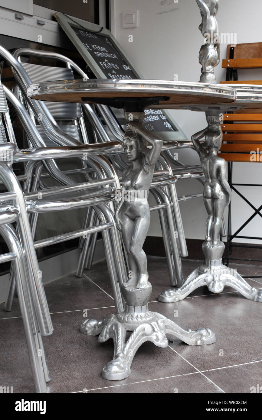 Surrealist style Chrome tables and chairs stacked outside a cafe in the ...