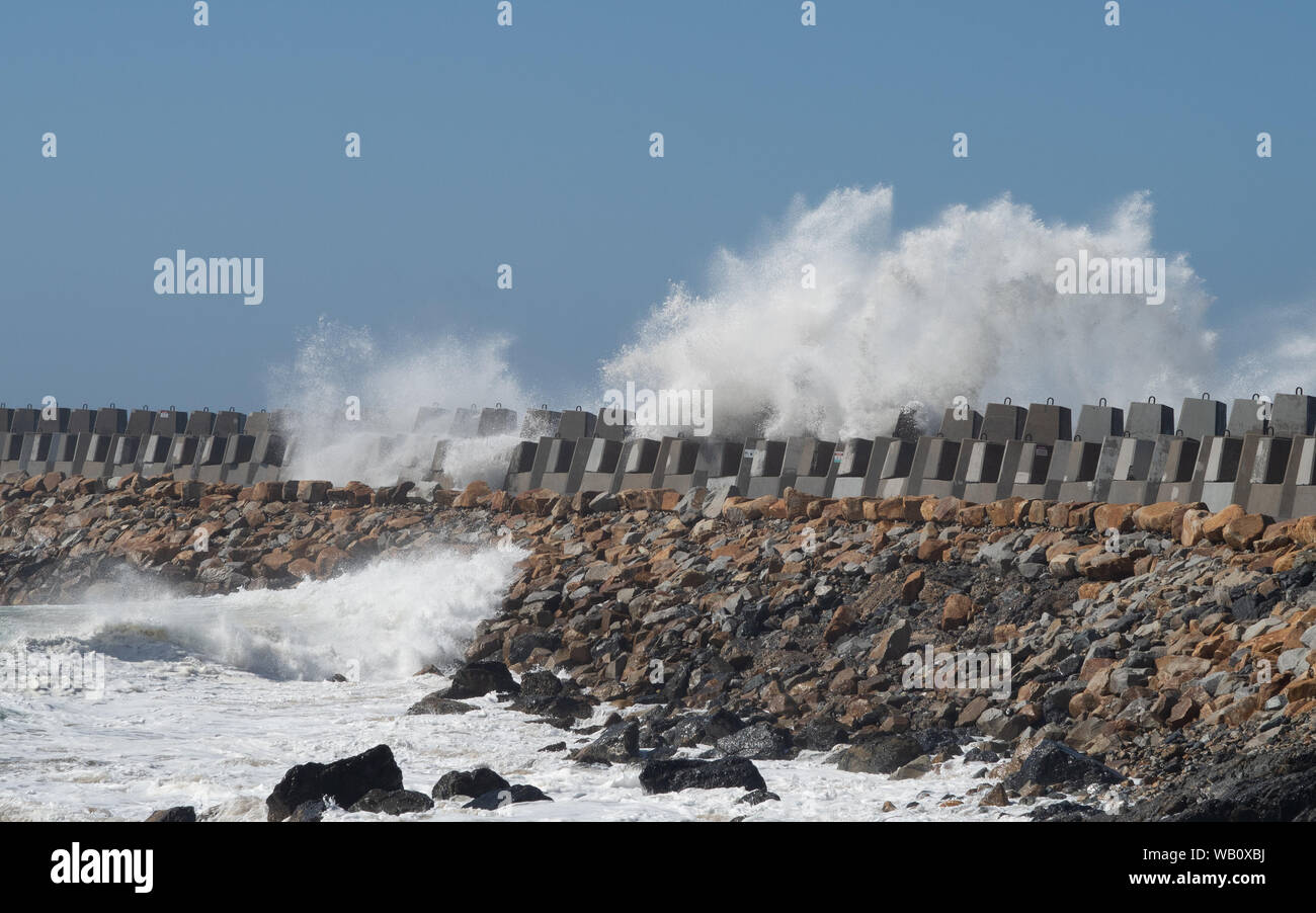 Rough sea. Waves smashing into and crashing up over the break wall at ...