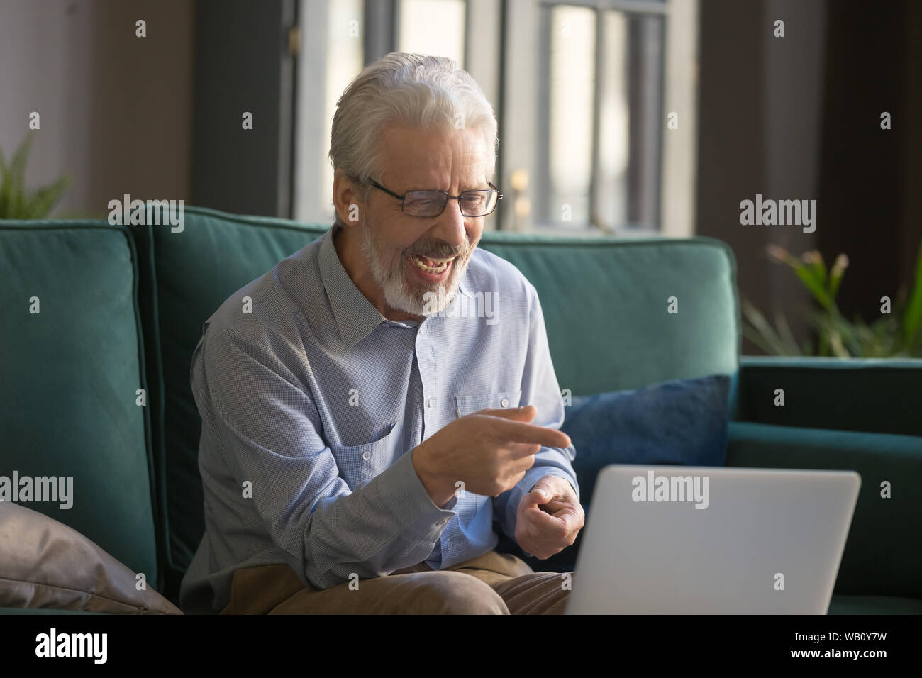 Happy old senior man laughing looking pointing at laptop screen Stock ...