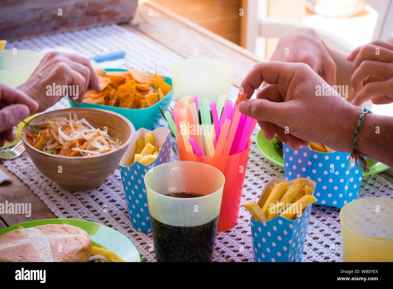 close up of hands taking chips and food of the table in a happy party ...