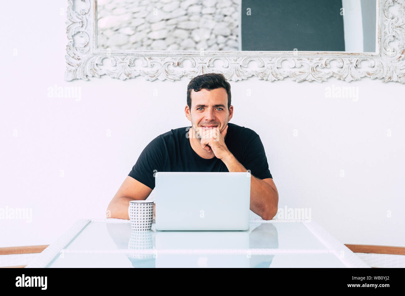Happy millennial business young man sit on his desk with modern ...