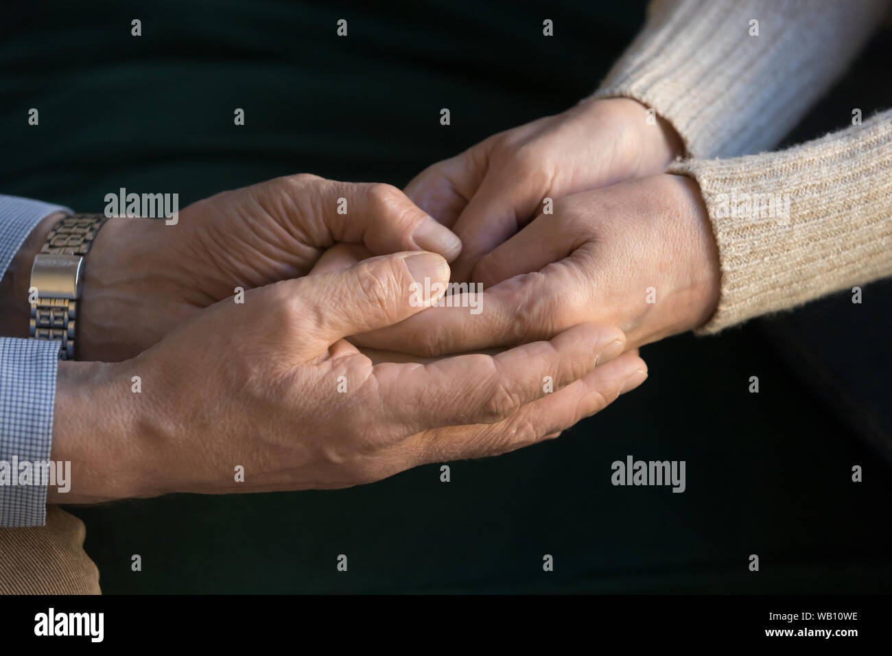 Elder husband holding hands of wife giving support, close up Stock ...