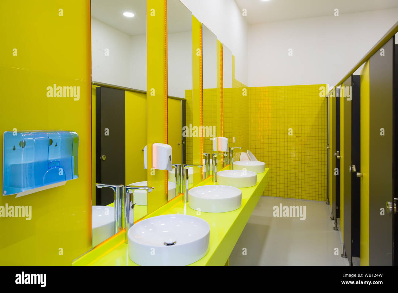 Toilet with cubicles with bright yellow walls. Modern toilet design ...