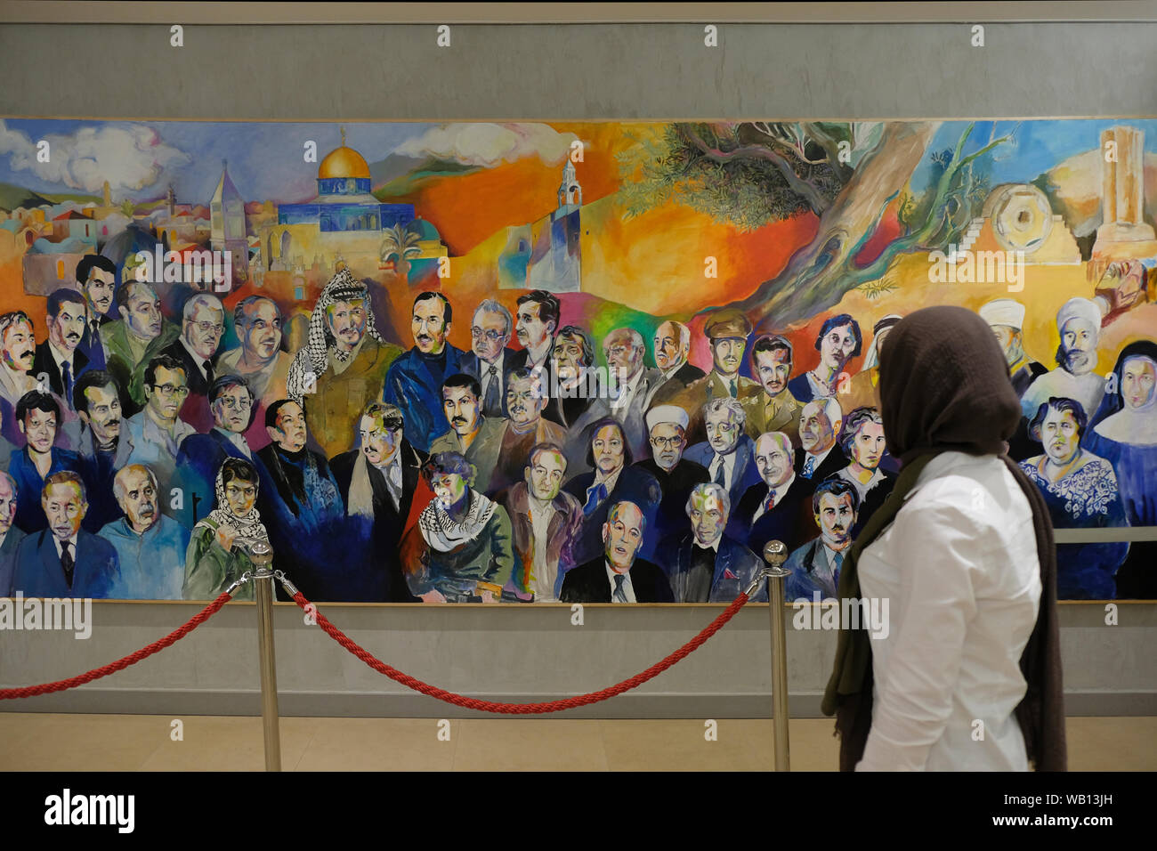 A Palestinian visitor view a mural painted by the Palestinian artist ...