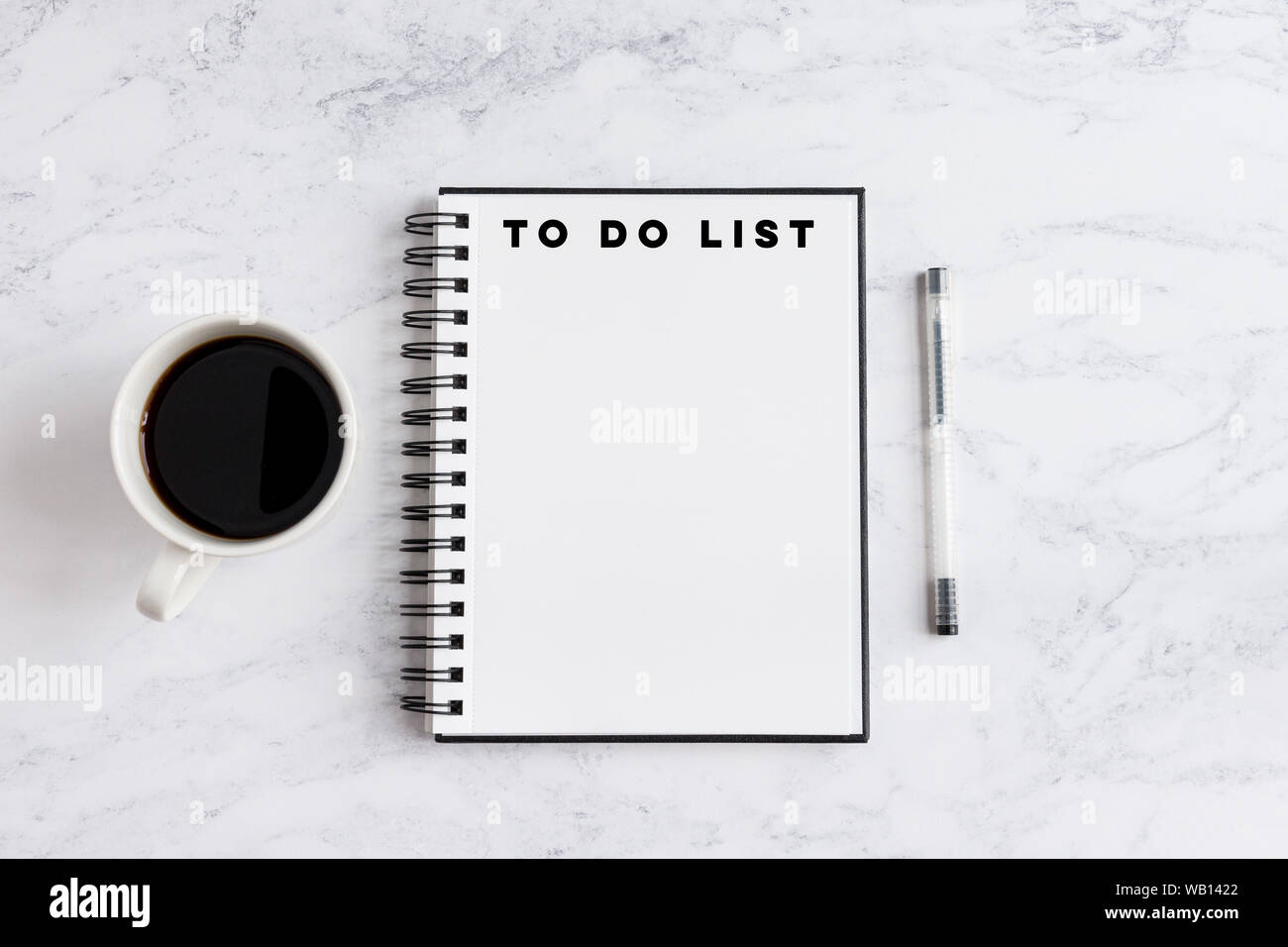 To do list writing on notebook. Notebook on desk with coffee cup and a ...