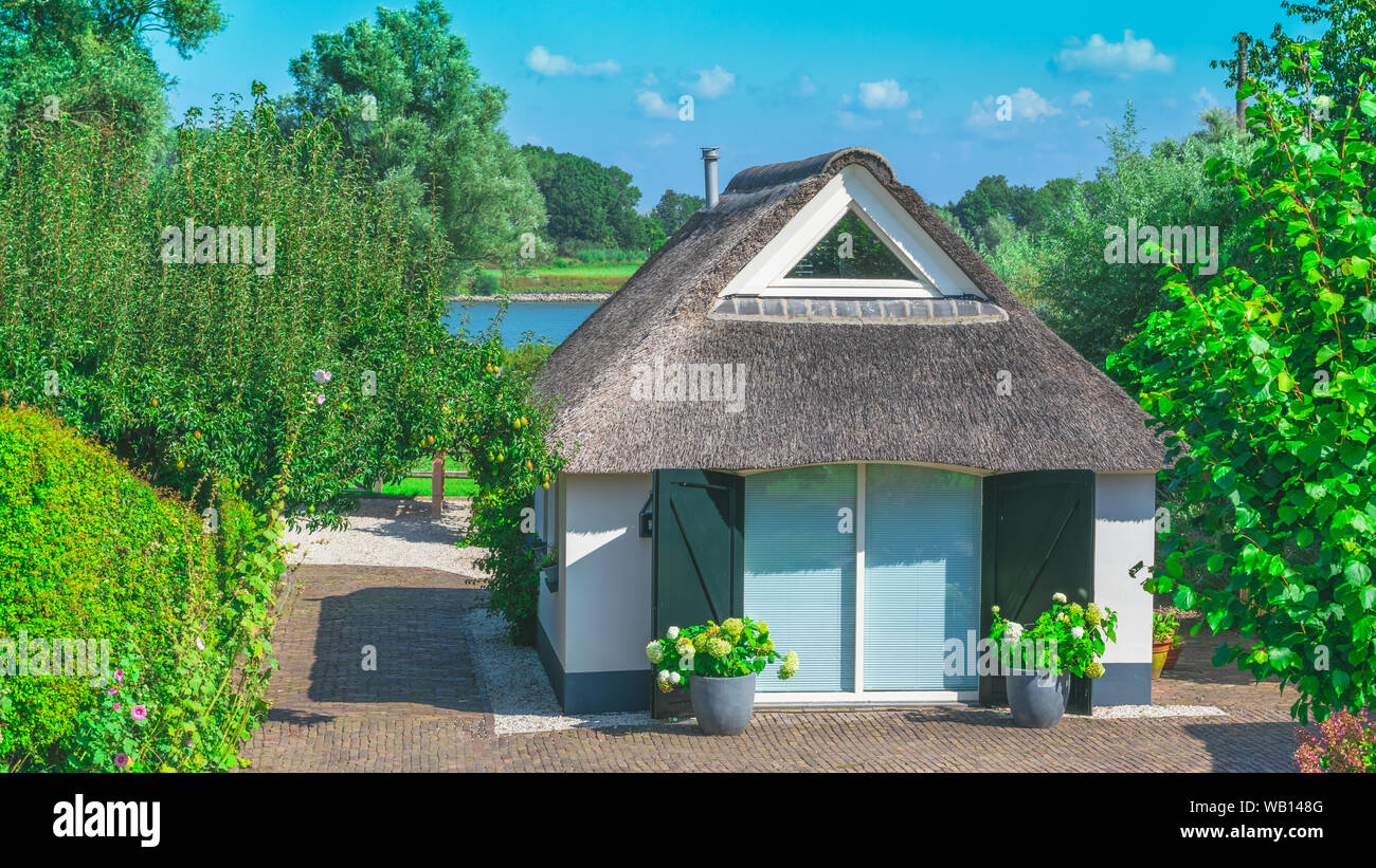 a traditional old Dutch house with a thatched roof in a typical Dutch ...