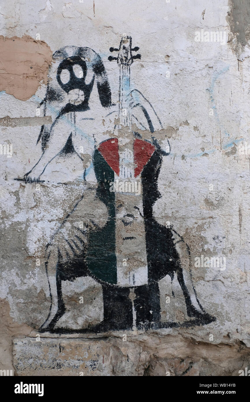 Graffiti depicting a female violinist wearing gas mask playing cello in ...