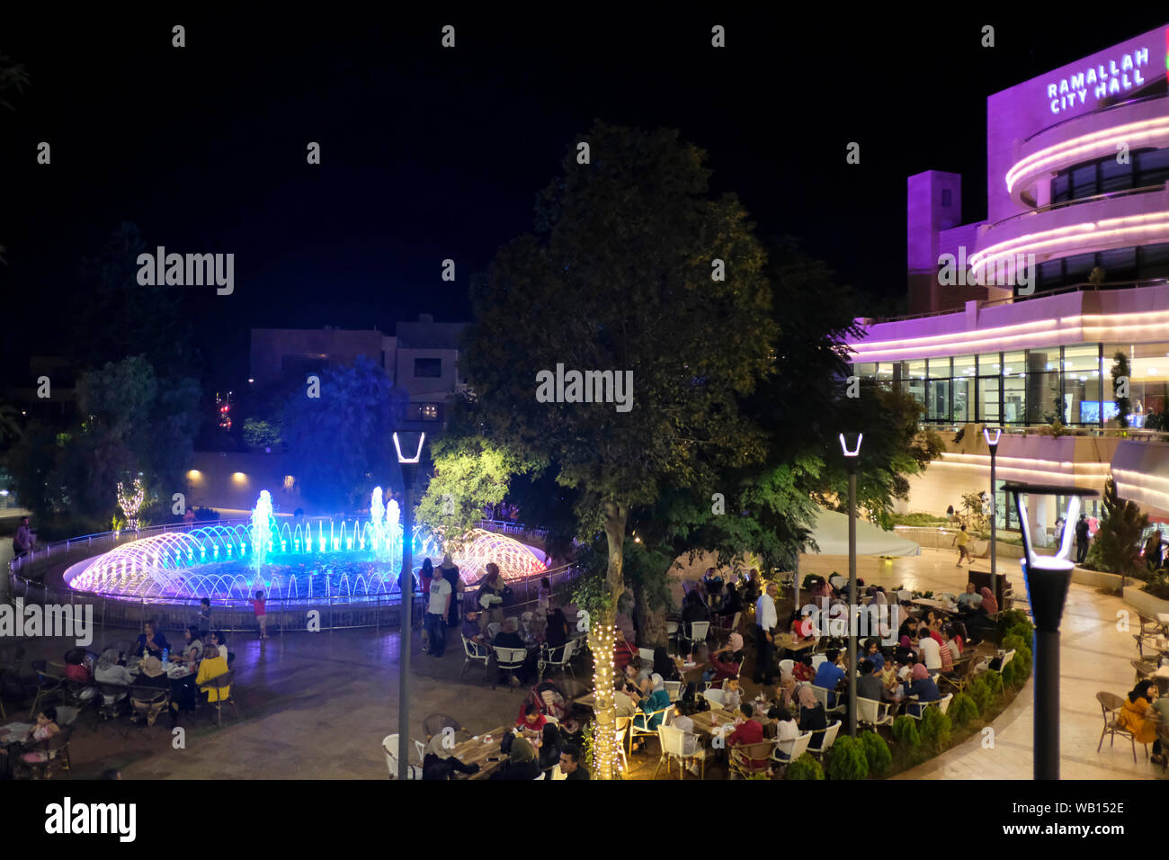Palestinians sitting in outdoor cafe at night at the municipality Park ...